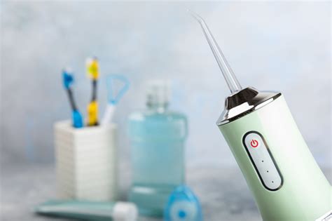 파란색 배경에 전자 구강 세정기 칫솔 페이스트 치실 및 구강 세정제 구강 위생을위한 치과 도구 전기 치간 청소기 치과용 물 샤워