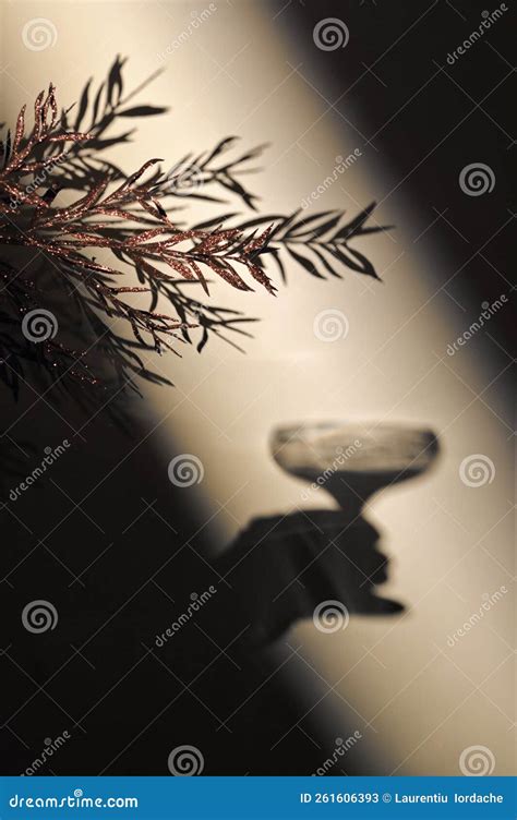 Shadow Hand Reaching Out To Hold Shadow Coffee Cup On Wooden Table