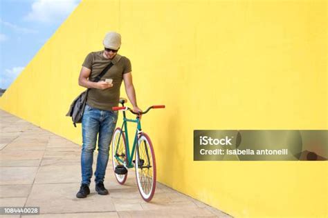 자전거 도시에서 길거리에서 노란 벽에 서 있는 동안 스마트 전화를 사용 하는 사람의 전체 길이 두발자전거에 대한 스톡 사진 및 기타 이미지 Istock