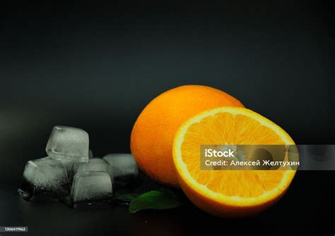 녹은 얼음 조각이 있는 신선한 컷 오렌지는 검은 색 배경에 놓여 있습니다 0명에 대한 스톡 사진 및 기타 이미지 0명 각얼음 감귤류 과일 Istock