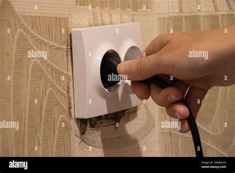 The Hand Includes A Plug In An Old Broken Socket In The Hallway Of The House Socket And Repair