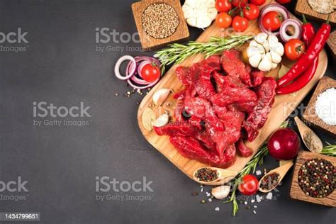 복사 공간이있는 어두운 콘크리트 배경 위에 향신료 칠리 고추 및 토마토를 곁들인 생 쇠고기 또는 양고기 고기를 다진 것입니다 스튜 Azu 또는 다른 고기 메인 요리를