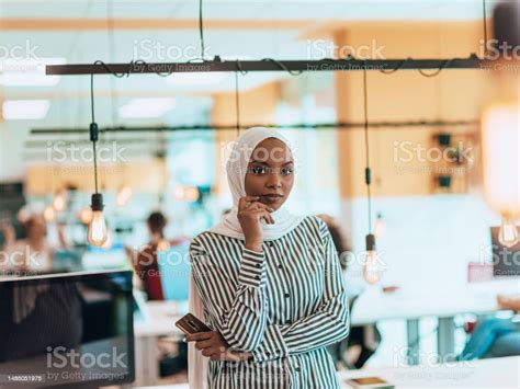 흑인 여성 무슬림이 히잡을 쓰고 현대적인 비즈니스 사무실에 서 있는 특성 경영자에 대한 스톡 사진 및 기타 이미지 Istock