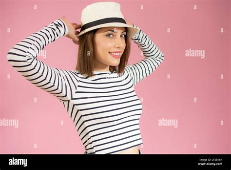 Portrait Of Young Beautiful Woman Wearing Straw Hat Smiling Looking At