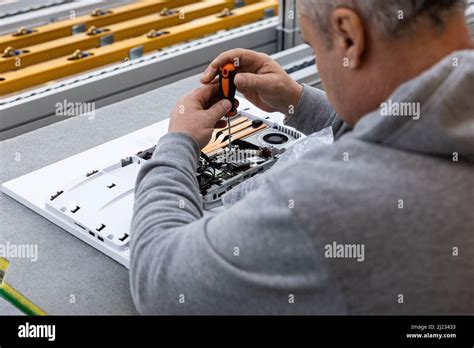 Photo Of An Adult Man In A Gray Sweater Who Assembles A Computer