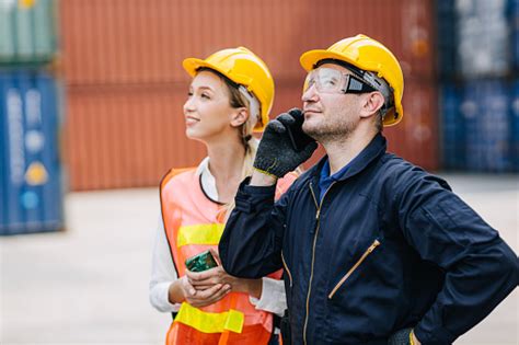 스마트폰 호출 명령을 사용하여 작업하는 물류 작업자 팀워크는 수출 및 수입 품을 위해 포트 화물의 컨테이너를 트럭에 적재합니다 직업에 대한 스톡 사진 및 기타 이미지