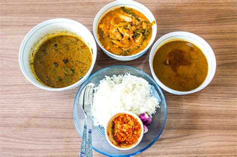 파란색 접시에 순수한 흰 재 스민 쌀의 상위 뷰가 있다 빨간 칠리 붙여넣기 한 잔 그리고 갈색 나무 테이블에 3 개의 포크 레드 카레 붙여넣기 갈색에 대한 스톡 사진 및