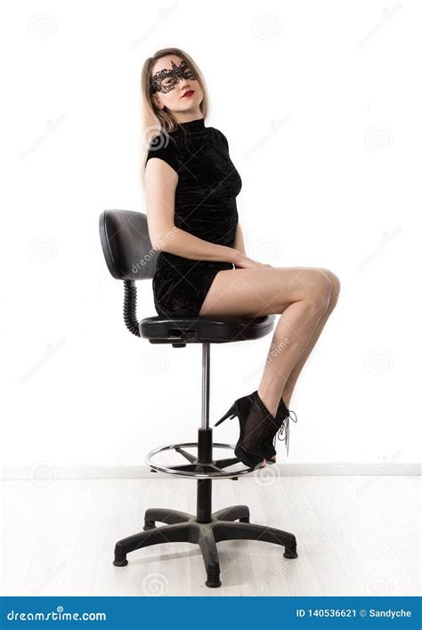 Elegant Womanin A Little Black Dress And Lace Mask Is Posing While