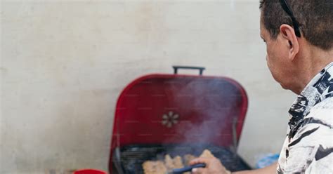 뒤뜰에서 가족의 점심을 위해 바베큐 그릴에서 고기를 준비하는 노인 사진 Unsplash의 피크닉 이미지