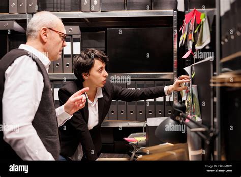 Investigators Analyzing Board With Crime Scene Evidence Working Late At Night At Criminal Case