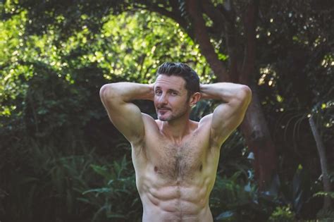Low Angle View Of Shirtless Older Man Standing Against Plants Premium