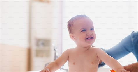 알아볼 수 없는 아버지는 집 실내 욕실에서 행복한 작은 유아 아들을 씻고 있다 사진 Unsplash의 욕조 이미지