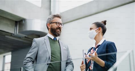 매력적인 승무원이 공항에서 사업가와 이야기하고 얼굴 마스크를 착용하고 있습니다 사진 Unsplash의 슬로바키아 이미지