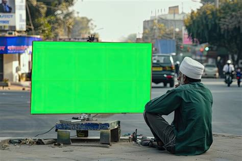 Indian Specialist Monitoring Traffic Surveillance Next To A Greenscreen