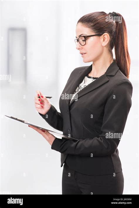 Brunette Business Woman With A Checklist Thinking Stock Photo Alamy