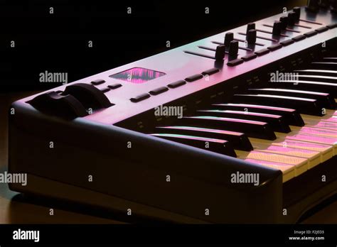 Deatil Of A Midi Keyboard With Modulation Wheel Lit By A Computer Screen A Waveform Is