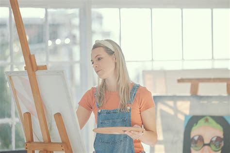 이젤과 컬러 팔레트를 사용하여 캔버스에 그림을 그리는 스튜디오나 작업장에서 여성과 함께 그림을 그리거나 예술을 하거나 창작하십시오 수채화 영감 예술적 젊은 여성 화가가 집에