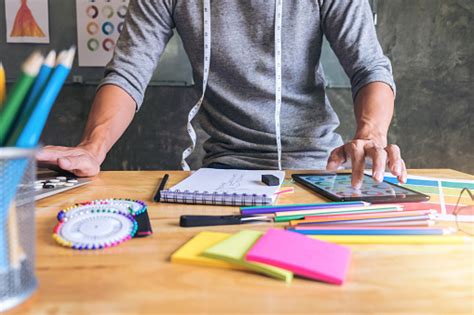 패션 디자이너 세련 된 개념 젊은 양 장점 또는 그리기 디자인 디자이너 옷에 대 한 작업을 스케치 하 고 제조 사무실 스튜디오에서 디지털 태블릿에 색상 막대를 선택 가위에