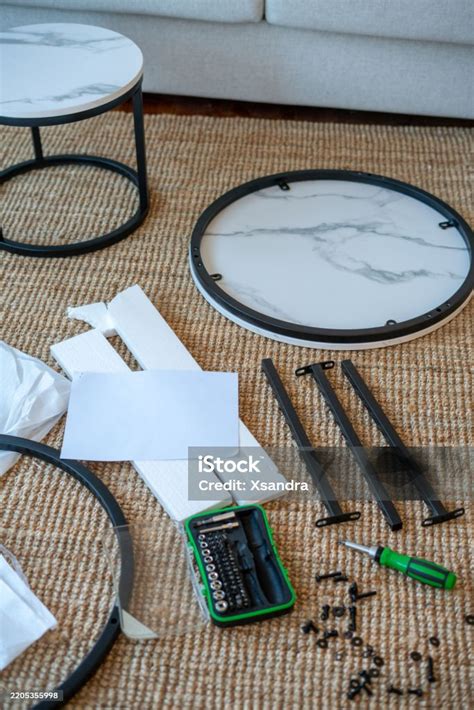 Assembling Furniture Parts Of A Modern Round Coffee Table Laying On