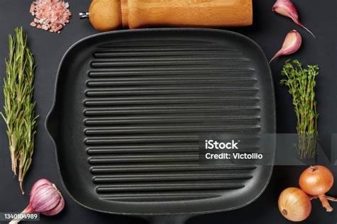 향신료와 조미료와 검은 테이블 배경에 사각형 빈 프라이팬 고기 나 야채를 굽기위한 철판 기구 텍스트에 대한 복사 공간이 있는 상단 보기입니다 번철에 대한 스톡 사진 및 기타