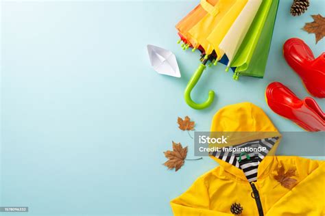 계절의 행복 아이의 노란 비옷 빨간 고무신 쾌활한 무지개 우산 종이배 단풍잎 파스텔 블루 배경에 솔방울 텍스트나 광고를 위한 공간을 남겨둔 최고의 장면 가을에 대한 스톡