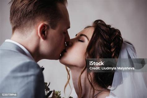 첫 번째 모임입니다 신랑은 꽃다발과 신부에게 방으로 온다 그들은 포옹하고 키스 핑크 웨딩 드레스 회색 정장과 세련된 꽃다발 모로코 스타일의 객실입니다 2명에 대한 스톡 사진