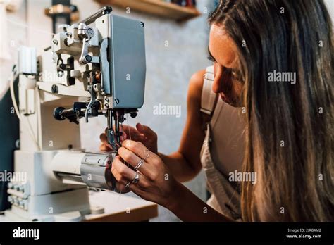 Fashion Designer Threading Needle In Sewing Machine At Workshop Stock