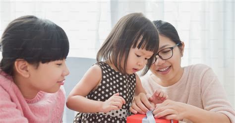 행복한 아시아 가족은 집의 하얀 방에서 생일 크리스마스 새해를 위한 빨간 선물 상자를 포장합니다 사진 Unsplash의 포장 이미지