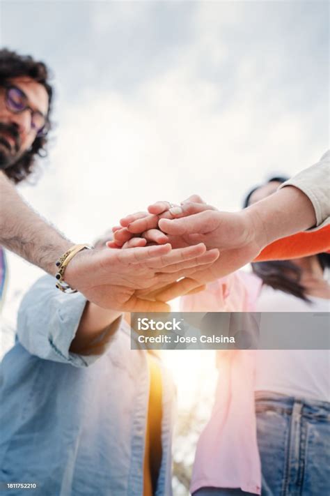 세로 한 무리의 젊은이들이 손을 모으고 작업 프로젝트를 위해 협력하는 낮은 각도의 모습 가장 친한 동료 팀은 서로 손을 얹고 있습니다 단합과 파트너십 팀워크에 대한 스톡