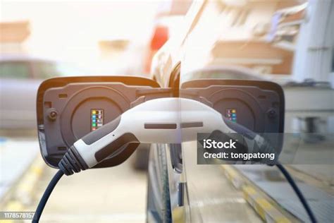 자동차의 미래인 거리에서 현대 전기차 배터리를 충전하고 하이브리드로 충전되는 전기 자동차에 전원 공급 장치를 닫습니다 차량 연료의 새로운 시대 전기 자동차 대체 연료