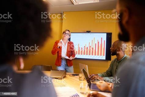 회의 중에 팀에 그래프 프레젠테이션을 제공하는 관리자 경영자에 대한 스톡 사진 및 기타 이미지 경영자 그래프 긍정적인