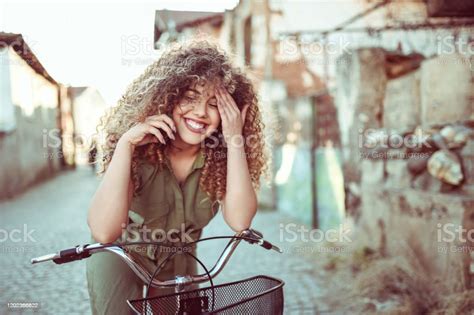 오래된 동네에서 자전거를 타는 동안 전화로 말하는 여성 거리에 대한 스톡 사진 및 기타 이미지 거리 건축 걷기 Istock