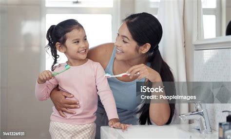 구강 또는 치아 건강을 위해 욕실에서 함께 칫솔로 양치질하는 법을 배우는 소녀와 함께하는 어머니 행복하고 사랑하며 돌보는 엄마는 아이 또는 아이에게 치과에 대해 가르치고