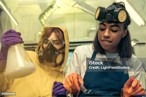 Portrait Of Woman Dividing Drugs With Friend Holding Flask Near By In Laboratory Drugs Concept