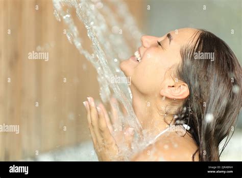 Side View Portrait Of A Happy Woman Enjoying Smiling Under Water Jet In