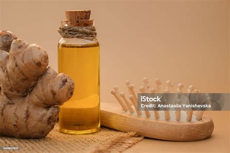 베이지 색 배경에 에센셜 생강 오일 생강 뿌리의 유리 병 건강한 대안 생활 헤어 케어를위한 천연 화장품 성분 웰빙 에코 빗 홈