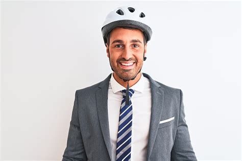 얼굴에 행복하고 시원한 미소와 고립 된 배경 위에 양복과 넥타이와 자전거 헬멧을 입고 젊은 잘 생긴 사업가 운이 좋은 사람 긍정적인 감정 표현에 대한 스톡 사진 및 기타