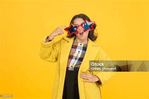 카니발 의상 유명한 유명 인사 록스타 여자 자신감 멋진 아이는 스타 모양의 선글라스를 착용합니다 스타 컨셉 명성과 인기 파티 휴일 축하 쾌활한 소녀는 재미를 위해 안경을