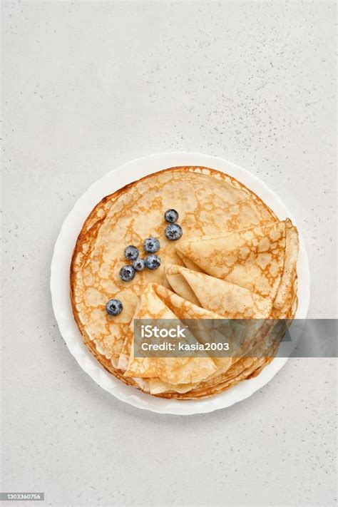 얇은 팬케이크 크레이프 또는 흰 접시에 열매를 곁들인 블리니 맨 위 보기입니다 팬케이크 주 슈로브타이드 텍스트 공간입니다