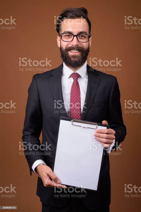 배경 색 안경을 쓰고 젊은 잘생긴 수염된 페르시아어 사업가의 스튜디오 샷 20 29세에 대한 스톡 사진 및 기타 이미지 20 29세 25 29세 갈색 배경 Istock