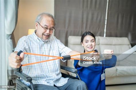 치료사 간호사의 지원으로 물리 치료사를하는 휠체어에 아시아 장애인 노인 노인 장애인 은 가정 간호에서 환자를위한 저항 스트레치 밴드 운동을 사용하여 물리치료에 대한 스톡