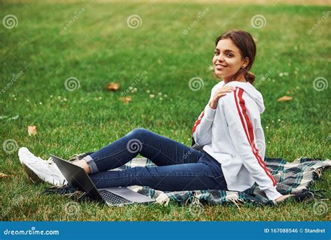 Side View Positive Girl In Casual Clothes With Her Laptop Sits On