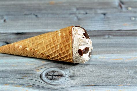 바삭한 웨이퍼 콘에 초콜릿 칩 조각을 토핑한 아이스크림 바닐라 콘 웨이퍼 비스킷에 차가운 아이스크림 돌리기를 녹이는 선택적 초점