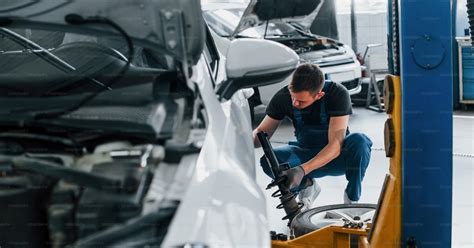 작업복을 입은 남자가 실내에서 차를 수리합니다 자동차 서비스의 개념 사진 Unsplash의 수송 이미지