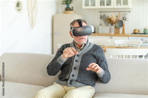 Excited Mature Senior Man Wearing Using Virtual Reality Metaverse Vr Glasses Headset At Home