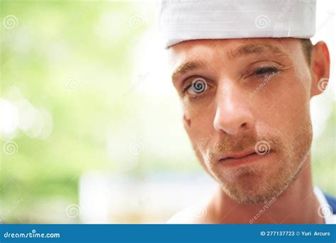 Playful Wink A Young Man Wearing A White Hat Winking At The Camera