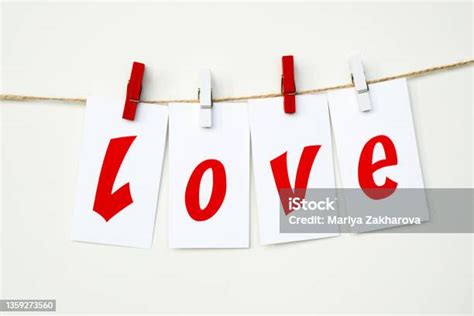 발렌타인 데이 인사말 카드 새겨진 Love가 새겨진 엽서는 흰색 배경의 옷핀에 끈을 걸고 있습니다 2월 14일 발렌타인 데이