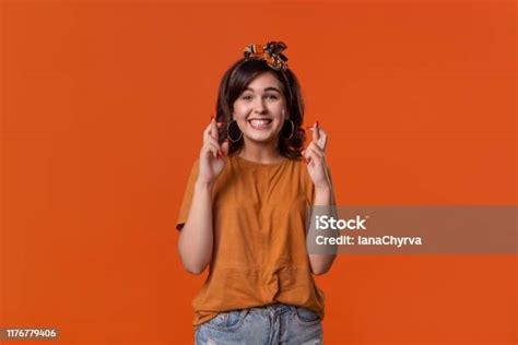 오렌지 색 티셔츠와 아름다운 머리띠를 들고 웃는 갈색 머리 여자는 오렌지 배경 위에 고립 된 꿈을 실현 실현 을 요구 교차 꿈의 개념 T 셔츠에 대한 스톡 사진 및 기타