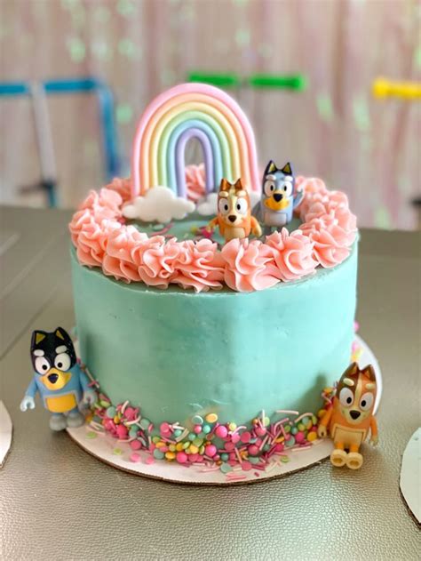 A Birthday Cake With Frosting And Cartoon Characters On The Top