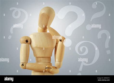 Wooden Mannequin In Thinking Pose With Quesion Marks Concept Of Question Thinking And Doubts